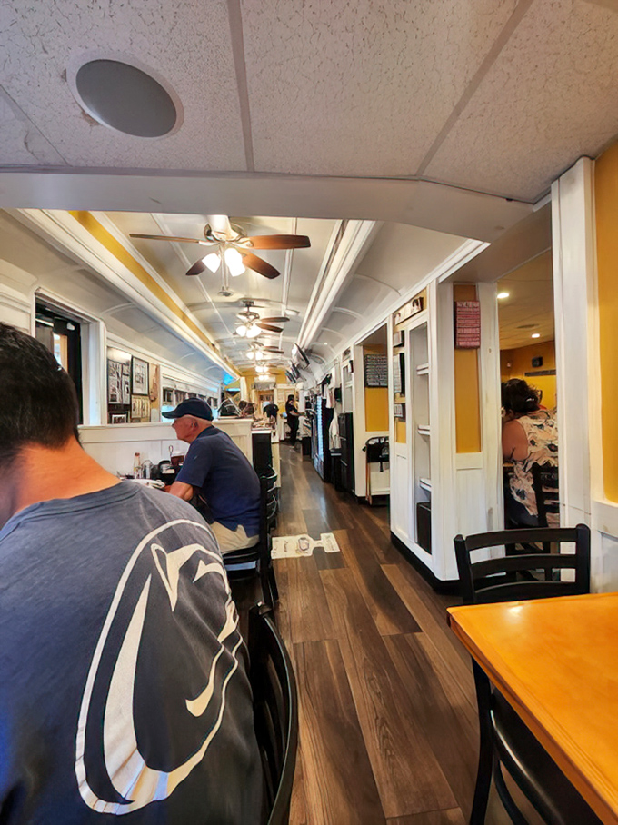 The narrow aisle creates an intimate dining experience where conversations flow as freely as coffee.