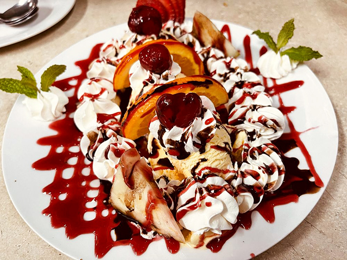 A dessert that's having more fun than most people. Ice cream, fruit, whipped cream, and enough cherry sauce to make your inner child do backflips.