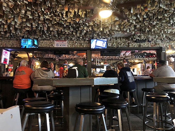 The bar at Shuckums&mdash;where locals and tourists unite under the common flag of fresh seafood and cold drinks. Those dollar bills overhead are watching your ordering decisions.