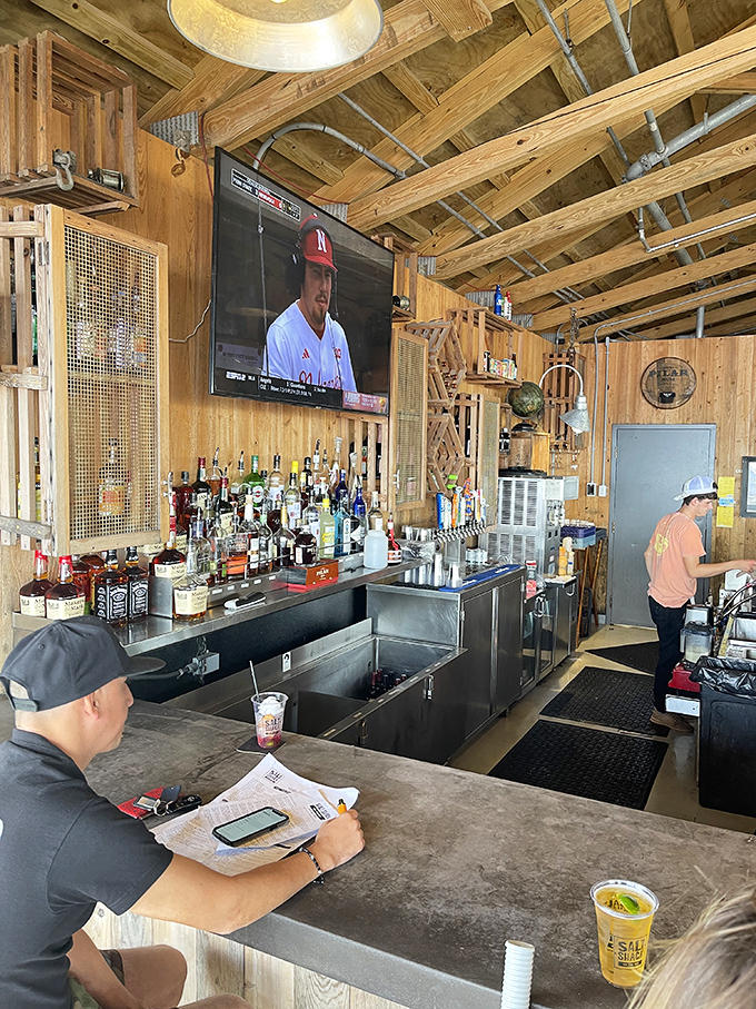 A bar that understands priorities: cold drinks, baseball on TV, and enough bottles to make any indecision a delightful problem to have.