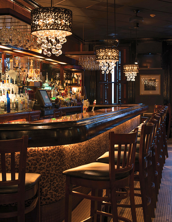 A bar that beckons with the promise of expertly crafted cocktails. Those crystal-draped light fixtures aren't just illumination&mdash;they're jewelry.