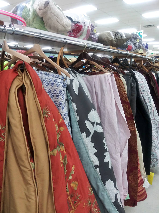 Racks of clothing topped with neatly folded linens&mdash;proof that organization can exist even in the most abundant thrift paradise.