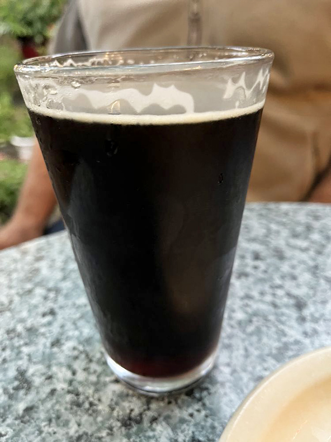 A proper pint of dark beer with that perfect cream top&mdash;proof that some traditions are worth preserving for generations.