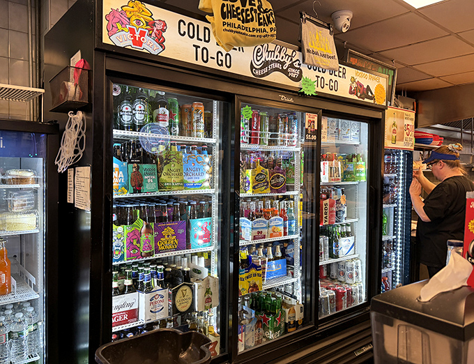 The beverage cooler&mdash;a colorful oasis of liquid refreshment options, because washing down greatness requires proper hydration choices.