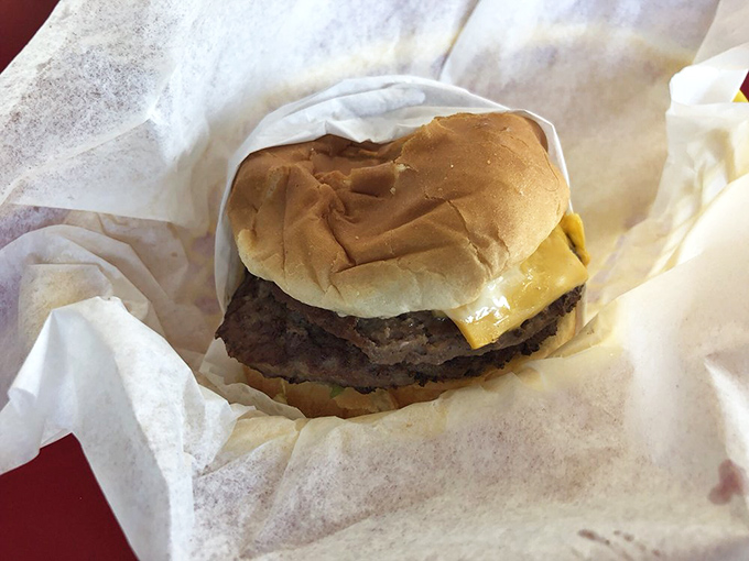 Nestled in white paper, this unadorned cheeseburger makes a compelling argument that perfection needs no garnish.