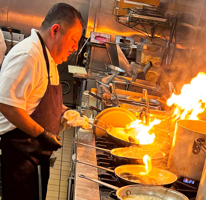 Culinary pyrotechnics in action! This chef isn't just cooking&mdash;he's performing a flame-kissed symphony that ends with your perfect meal.