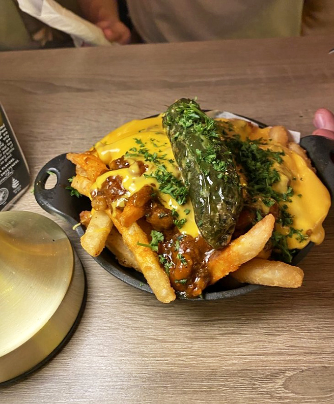 Chili cheese fries that don't know the meaning of restraint. That jalapeño standing tall like a flag planted on the summit of Mount Delicious.