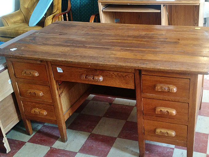 A desk with the gravitas of a bygone era when correspondence meant penmanship and drawers held secrets instead of charging cables.