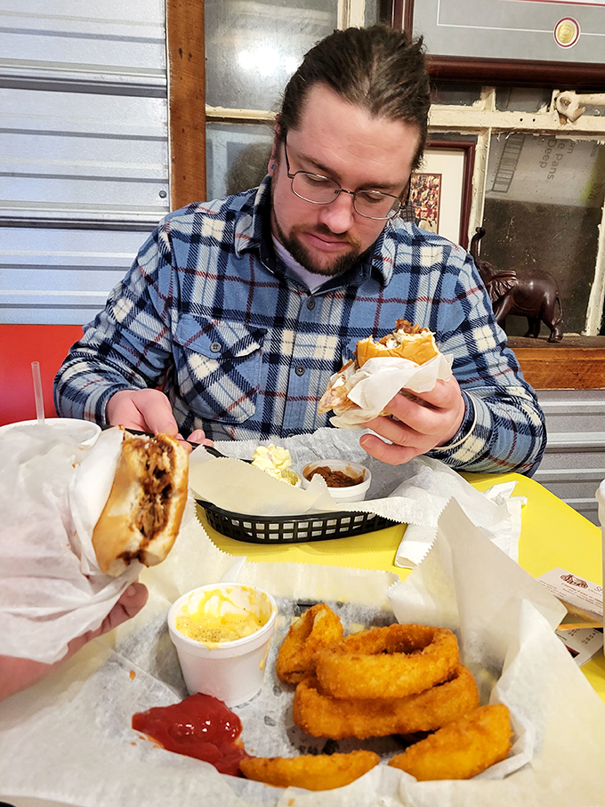 The focused concentration of a man meeting his sandwich soulmate. Those onion rings are the supporting cast in this delicious drama.