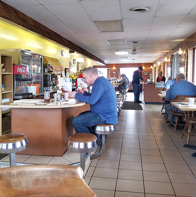 Morning light streams through windows as regulars perform the daily ritual of coffee, conversation, and comfort food.