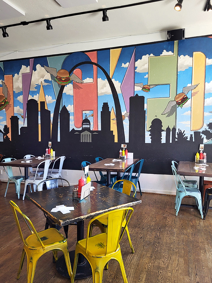 St. Louis pride shines through this mural where flying burgers soar past the iconic Gateway Arch like delicious UFOs.