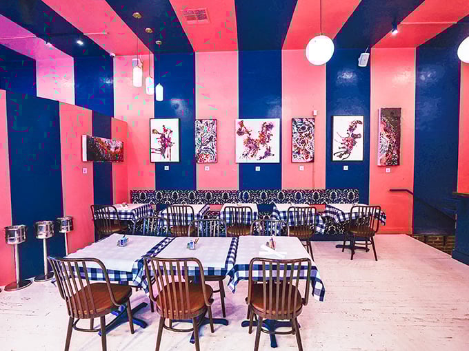 Bold coral and navy stripes create a dining space that's part circus tent, part art gallery—a playful backdrop for serious breakfast business.