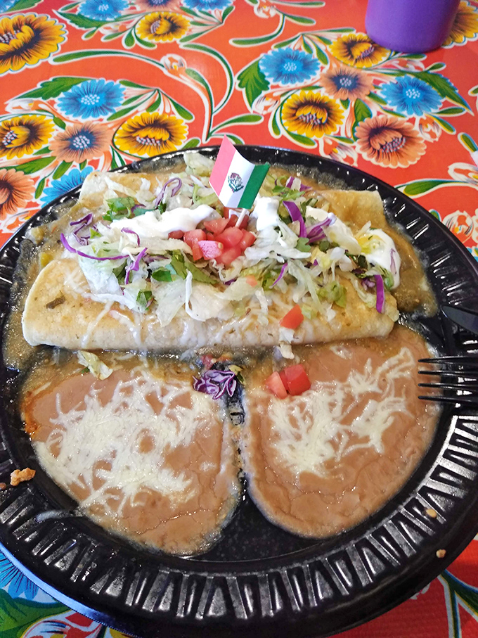 Enchiladas drowning in sauce with that perfect little Mexican flag declaring victory over hunger pangs.