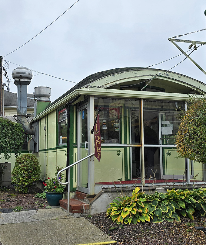 Even on a cloudy day, the diner's entrance beckons with mint-green promise. Those vintage vents and curved lines speak a design language from a more optimistic era.