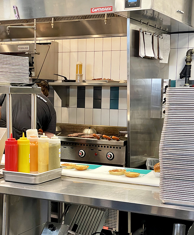 Where the magic happens&mdash;fresh patties hitting the hot grill while condiment bottles stand at attention, ready for duty.