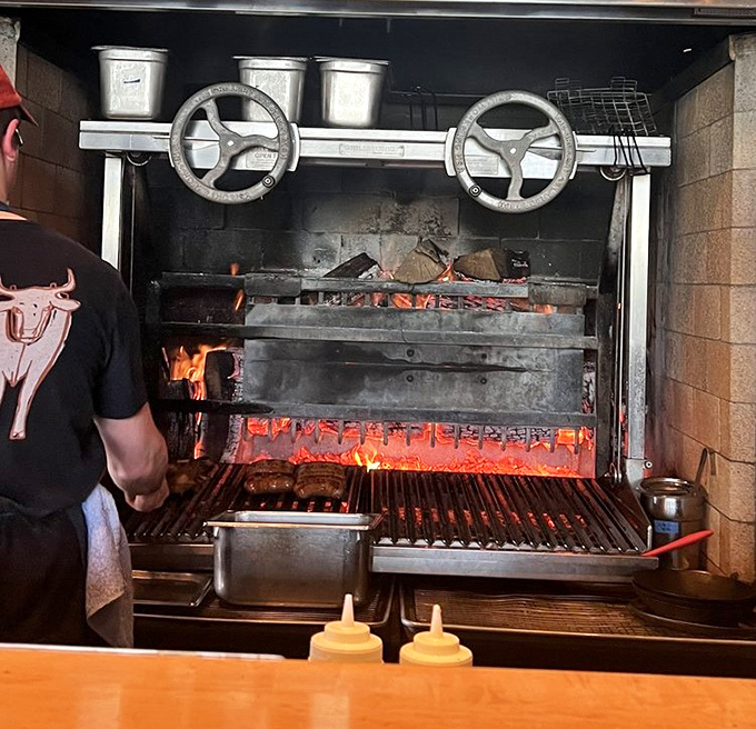 The heart of Ox: a custom-built wood-fired grill where flames dance beneath soon-to-be masterpieces of meat.