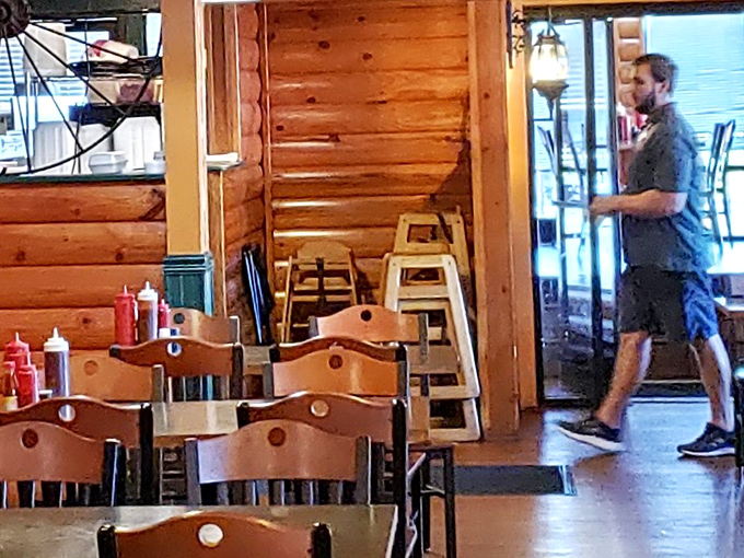 Simple wooden chairs and log cabin walls create that rustic charm that says, "We're focusing on the meat, not the seats." Sauce bottles standing by for duty.