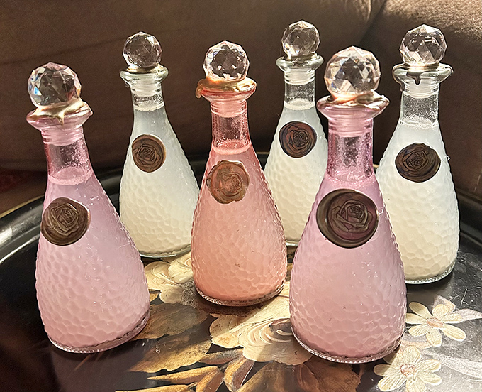 Delicate bottles with crystal stoppers catch the light like liquid jewelry – elegant vessels for perfumes or potions of your choosing.
