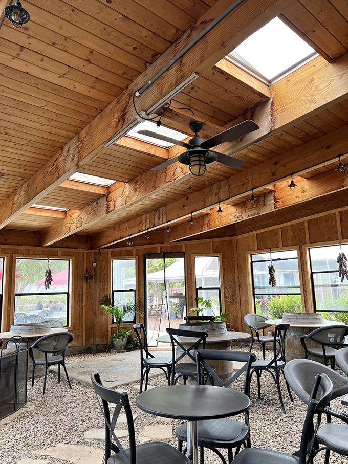 Natural light floods this sunroom dining space, where wooden beams frame meals that become the highlight of many California road trips.