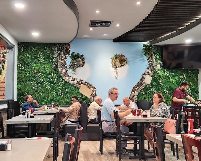 Diners enjoying their meals against a backdrop that brings the outdoors in. That plant wall creates an atmosphere where both conversations and appetites flourish.