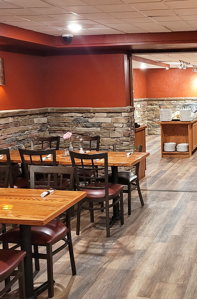 Warm terracotta walls and stone accents create a cozy dining atmosphere. That small flower centerpiece adds just the right touch of homey charm.