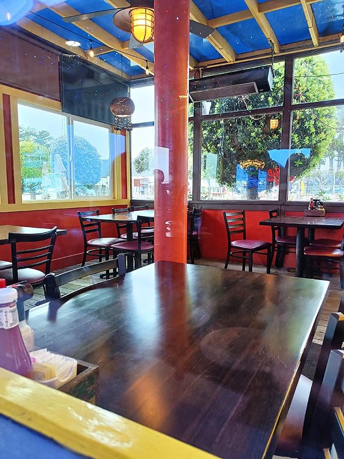 Red walls, blue ceiling, and natural light create the perfect backdrop for seafood feasts and conversations that flow as easily as the nearby tide.