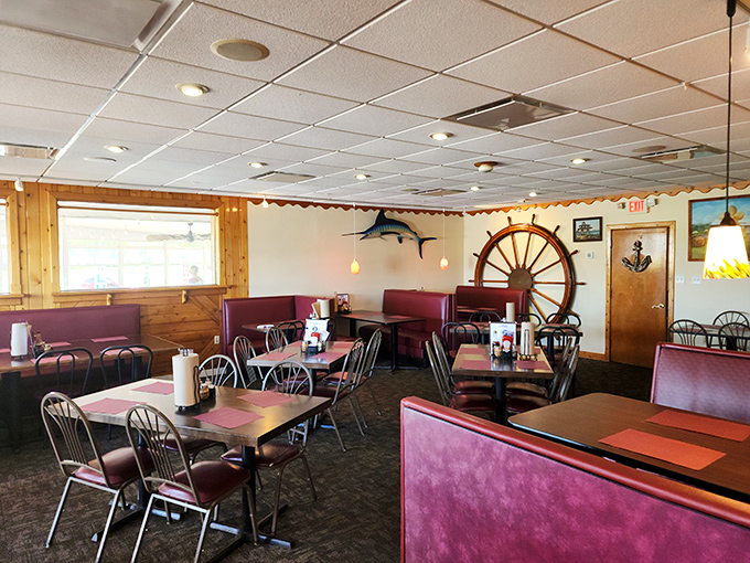 Burgundy booths, nautical wheels, and marlin mounts create that classic seafood joint atmosphere where comfort trumps pretension every time.