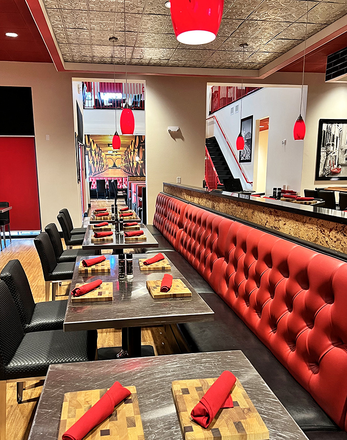 Red banquettes and warm lighting create the perfect backdrop for memorable dining experiences.