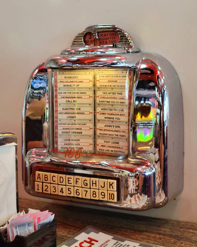 The tabletop jukebox isn't just playing songs—it's offering a soundtrack for your meal from an era when music came with mechanical magic.