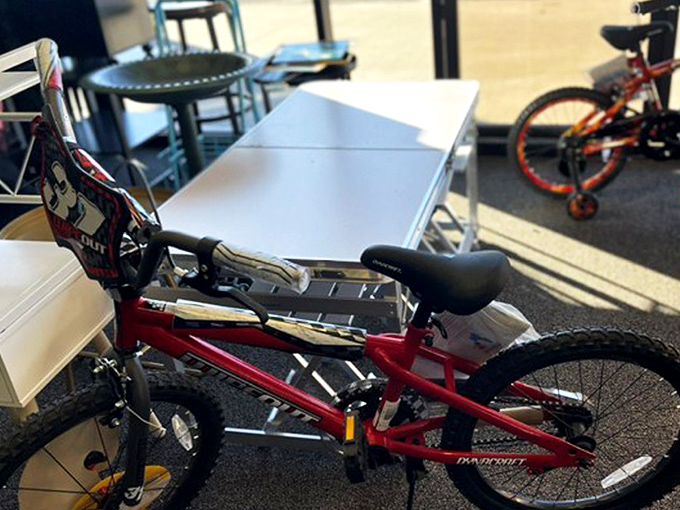 A child's first taste of freedom on two wheels, waiting for its next adventure with training wheels already installed.