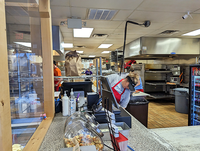 A glimpse into the kitchen reveals the pizza-making magic happens with practiced precision – no smoke and mirrors, just honest culinary craftsmanship.