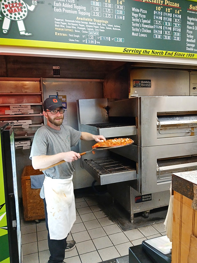The pizza-making process on display &ndash; a skilled hand wielding the pizza peel with the confidence that comes from thousands of perfect pies.