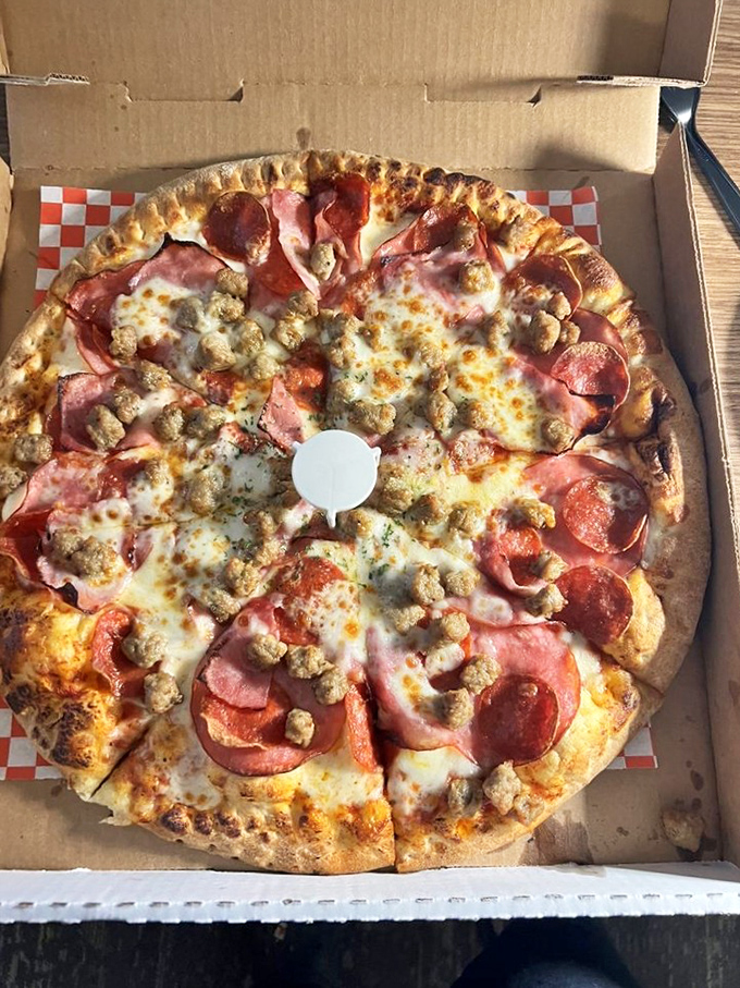 The carnivore's delight. This meat-lover's pizza showcases a perfect ratio of pepperoni, ham, sausage, and cheese that would satisfy any appetite.