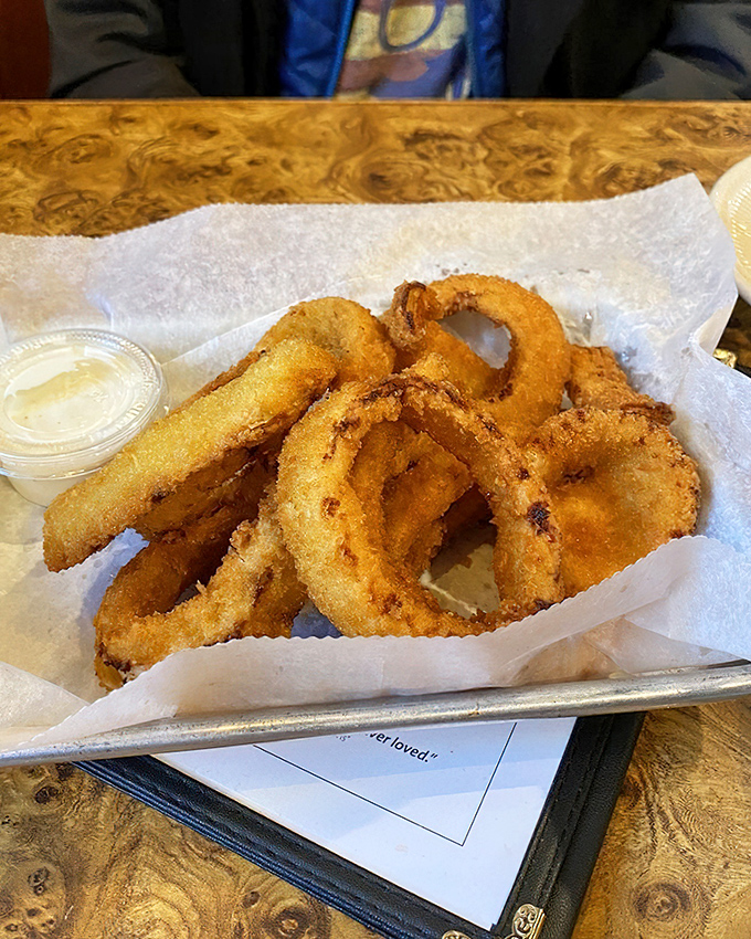 Onion rings with the structural integrity of Olympic medals. That dipping sauce is standing by like a loyal friend.