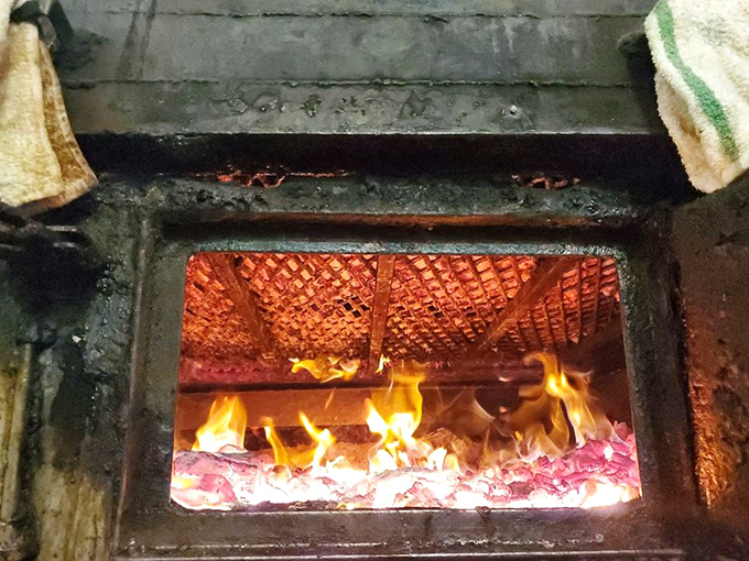 The heart of the operation: flames licking at meat on the grill. This isn't cooking&mdash;it's a primal ritual that's been perfected over generations.