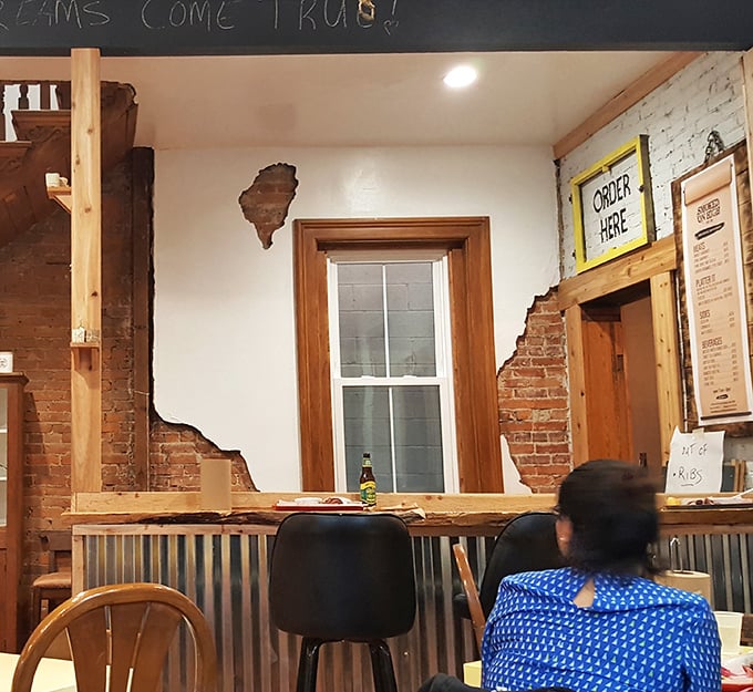 The order counter&mdash;where dreams become reality and decisions become dinner. That exposed brick and rustic wood trim screams "authentic" before you take your first bite.