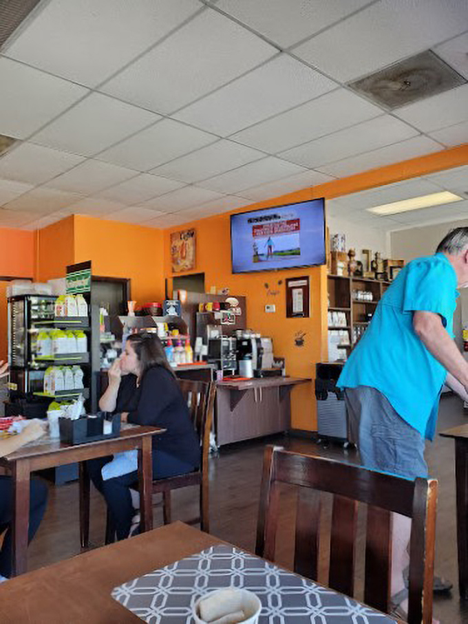 The cozy interior offers a casual atmosphere where the vibrant orange walls seem to amplify both conversation and appetite.
