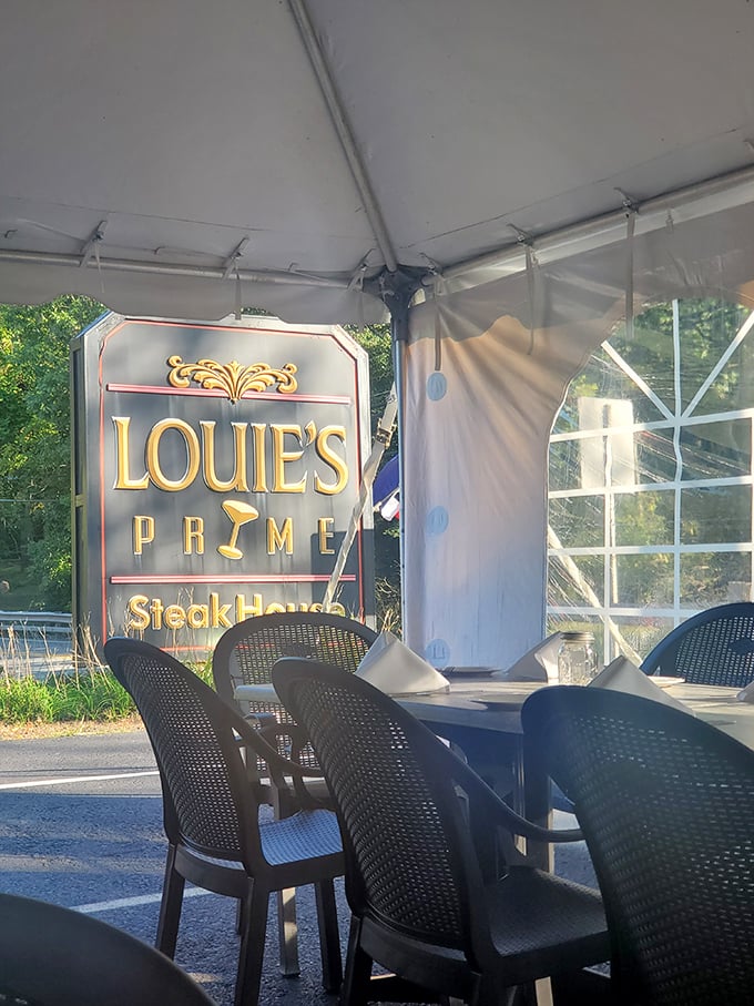 Outdoor dining under a tent with the Louie's sign watching over you – like a carnivorous guardian angel promising meaty salvation.