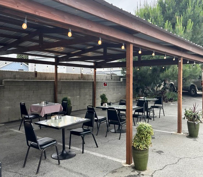 The outdoor seating area offers al fresco dining under simple string lights&mdash;California casual meets breakfast brilliance.