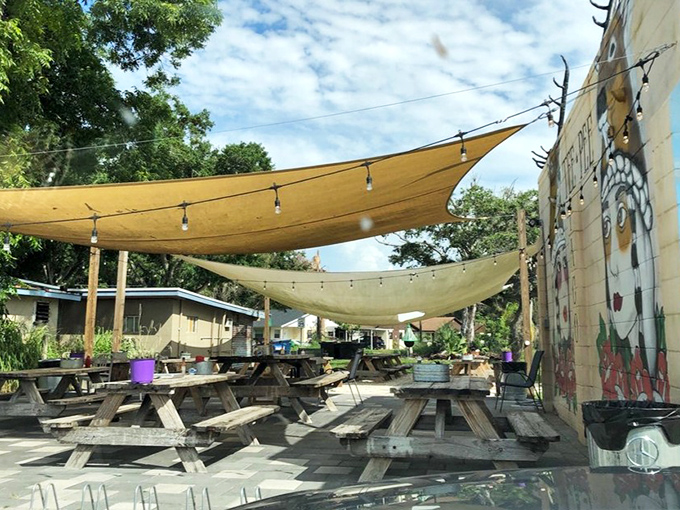 The outdoor seating area: where canvas sails provide shade and picnic tables invite lingering conversations over the last bites of key lime pie.