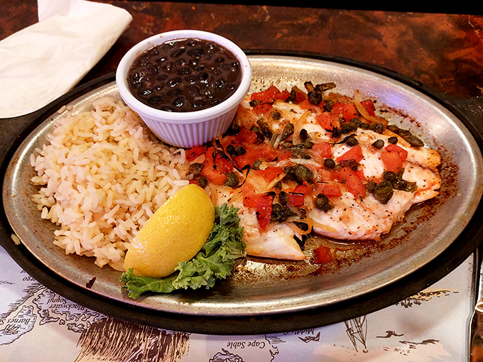 A perfectly seared fish fillet topped with fresh tomatoes and capers, proving that sometimes the simplest preparations let quality shine.