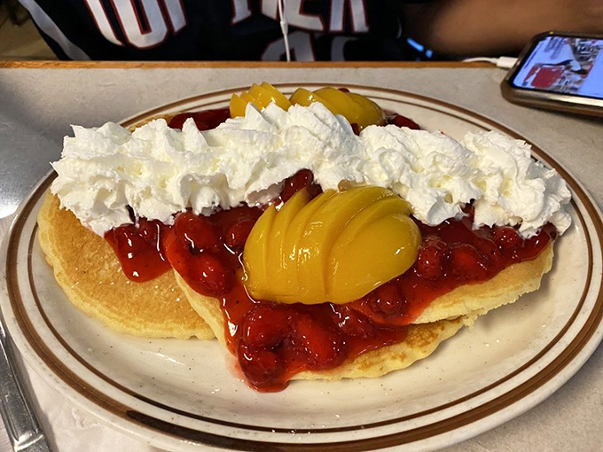Pancakes adorned with strawberries, peaches, and enough whipped cream to make a cloud jealous. Breakfast or dessert? The correct answer is "Yes."