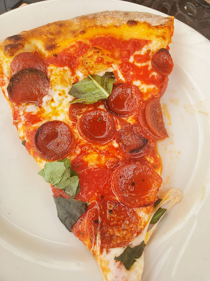 Pepperoni that curls into perfect little flavor cups, holding their savory oils like tiny offerings to the pizza gods. Pure coal-fired magic.