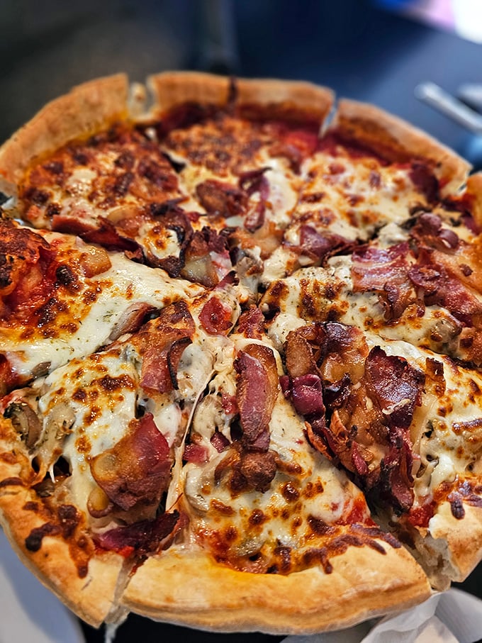 This isn't just pizza—it's a meat lover's dream with bacon and toppings generously scattered like confetti at a carnivore's parade.