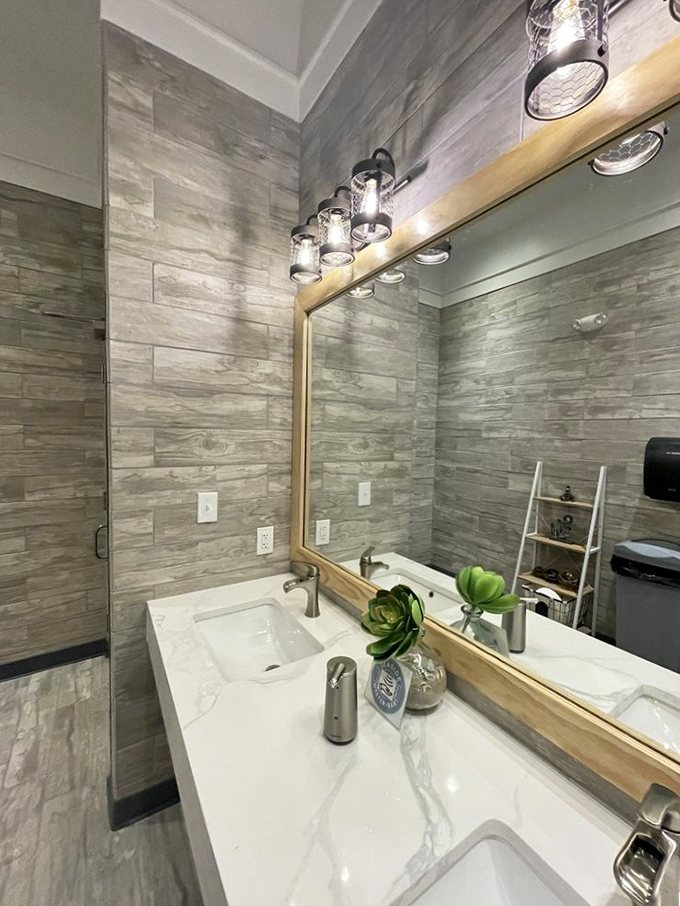 Even the restroom continues the upscale coastal theme. Driftwood-inspired tiles and elegant fixtures prove attention to detail extends to every corner.