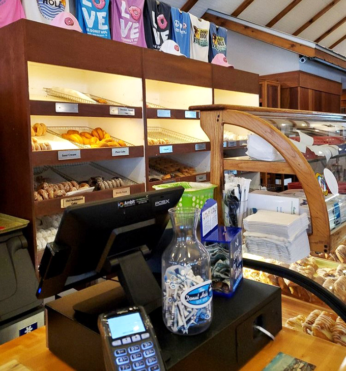 Donut displays that make willpower crumble faster than their apple fritters. The t-shirts hanging above suggest a loyal following of regulars.