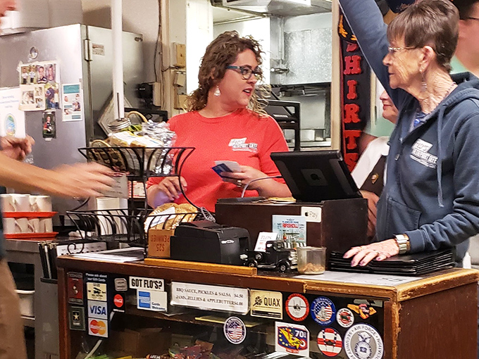 The register area, adorned with decades of stickers and memorabilia, serves as both business center and museum of local history.