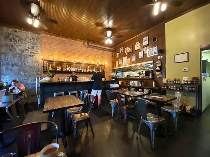 The bar area - where bottles gleam against exposed brick like an art installation dedicated to the craft of good drinks.