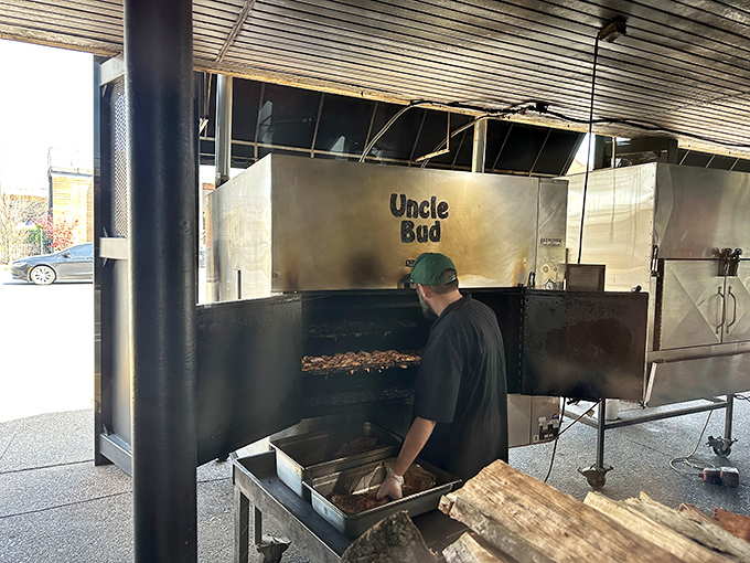 The pitmaster at work, tending to "Uncle Bud"&mdash;the smoker that's seen more meat than a butcher's convention. This is where the magic happens.
