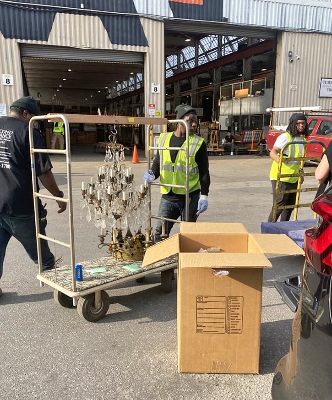 The dedicated staff carefully transports a crystal chandelier that once illuminated someone's special occasions and will soon light up another family's memories.